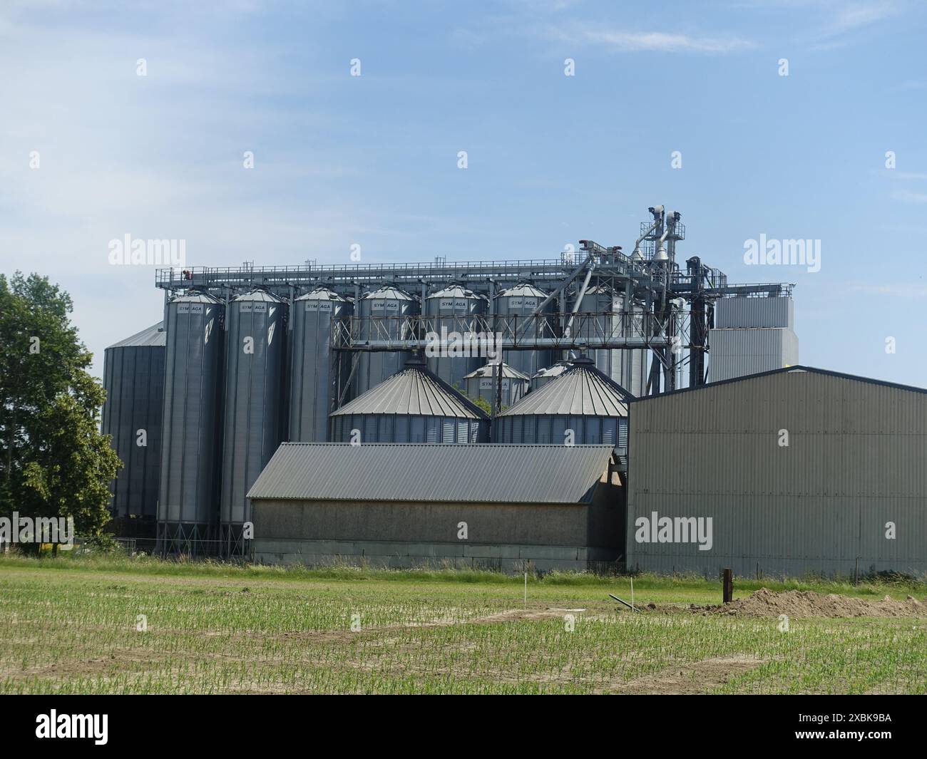 A large industrial grain silo complex in a rural area under a clear ...