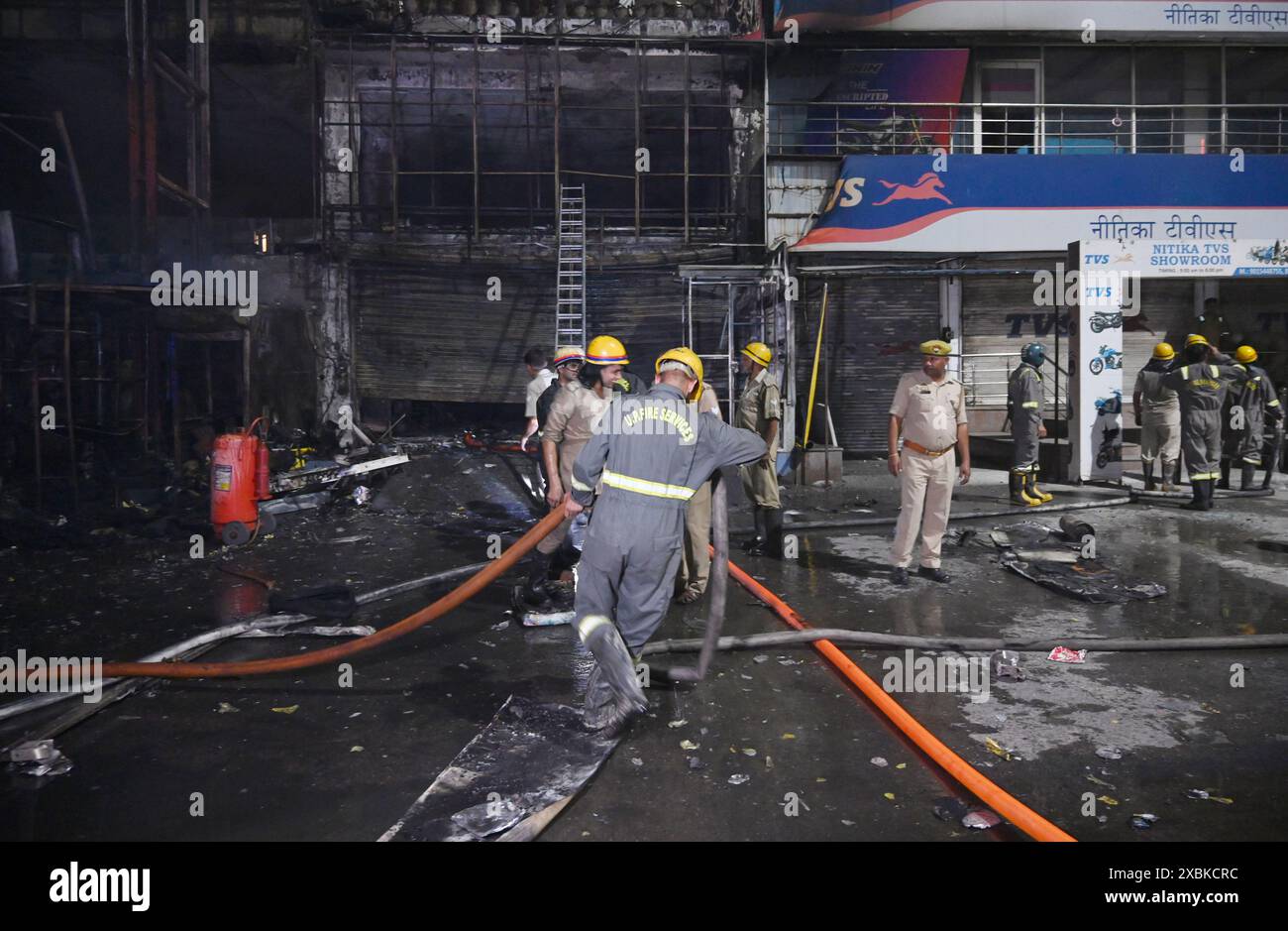 NOIDA, INDIA - JUNE 12: Fire brigade personnel extinguish the fire at shop adjacent to the ...