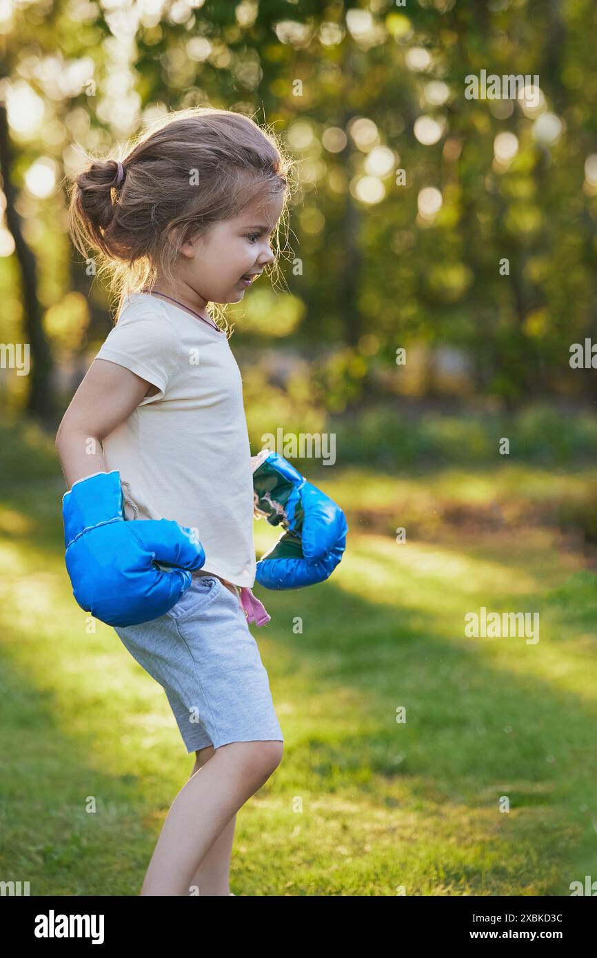 Charming child doing boxing in the backyard on the Sunset Stock Photo ...