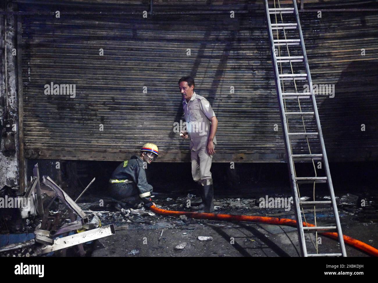 NOIDA, INDIA - JUNE 12: Fire brigade personnel extinguish the fire at shop adjacent to the ...