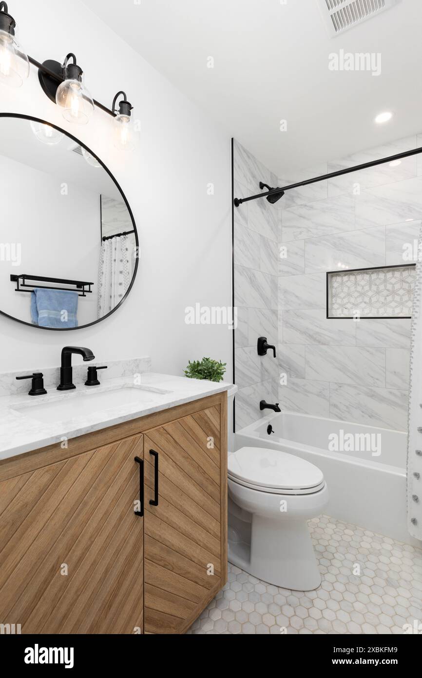 A bathroom with a white oak cabinet, white marble countertop, hexagon ...