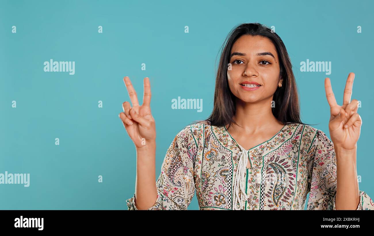 Jolly indian person doing peace victory hand sign gesture, studio ...