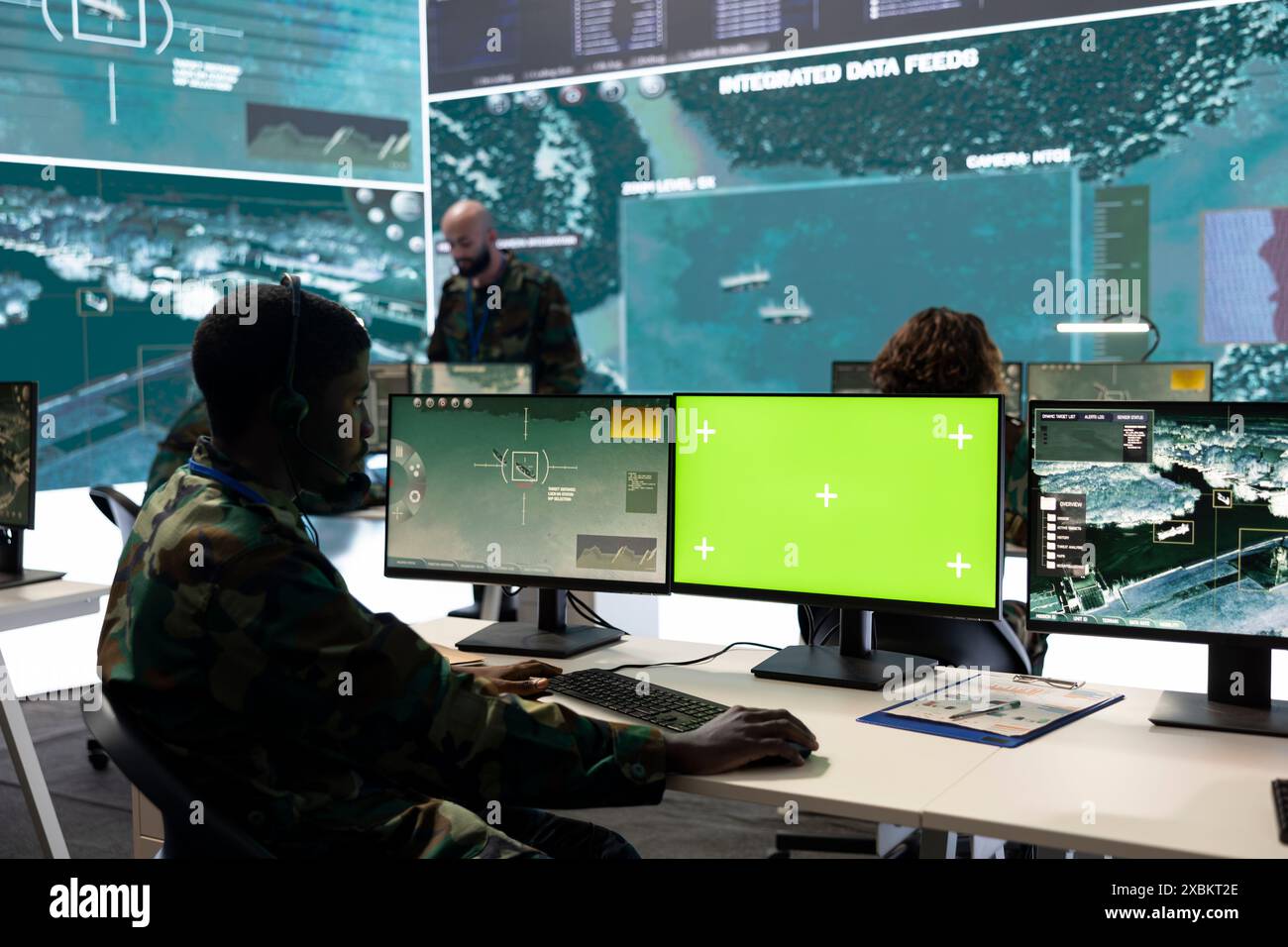 Army personnel monitors isolated green screen and surveillance footage, gathering important ...