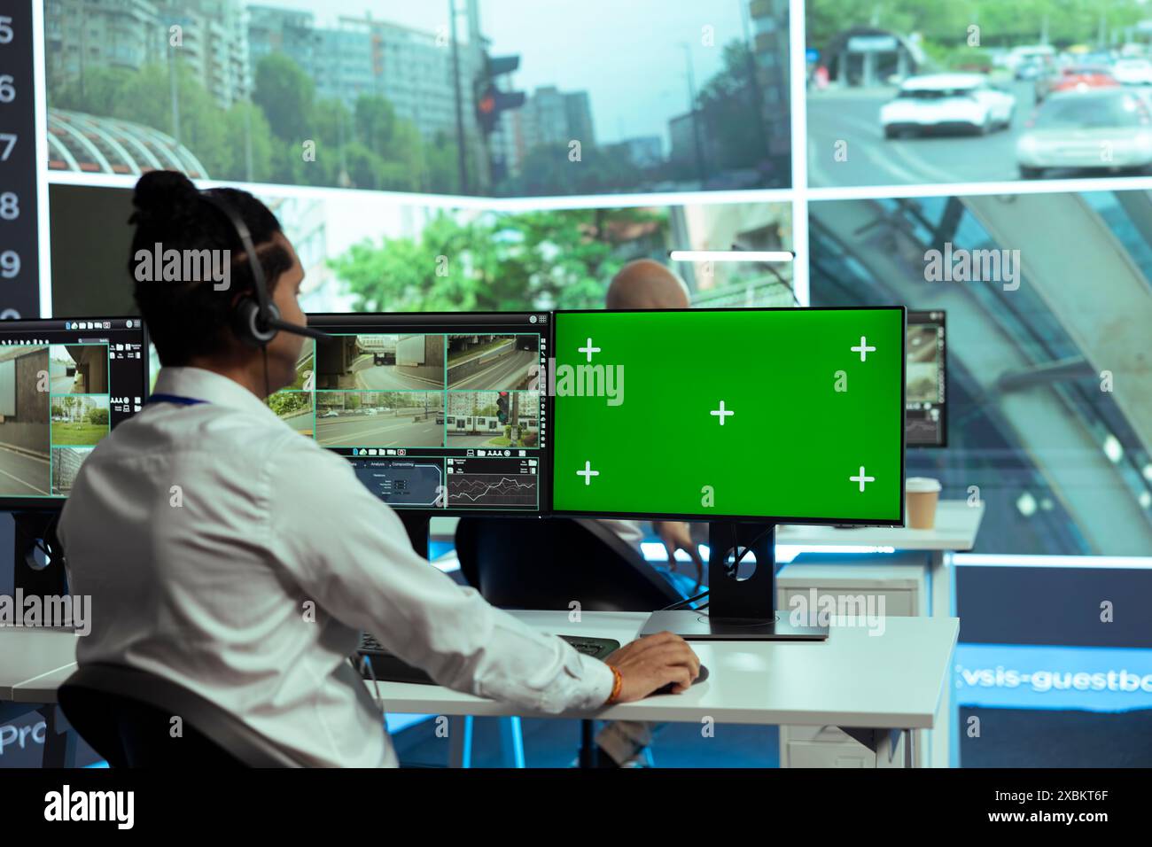 Indian specialist monitoring traffic surveillance next to a greenscreen ...