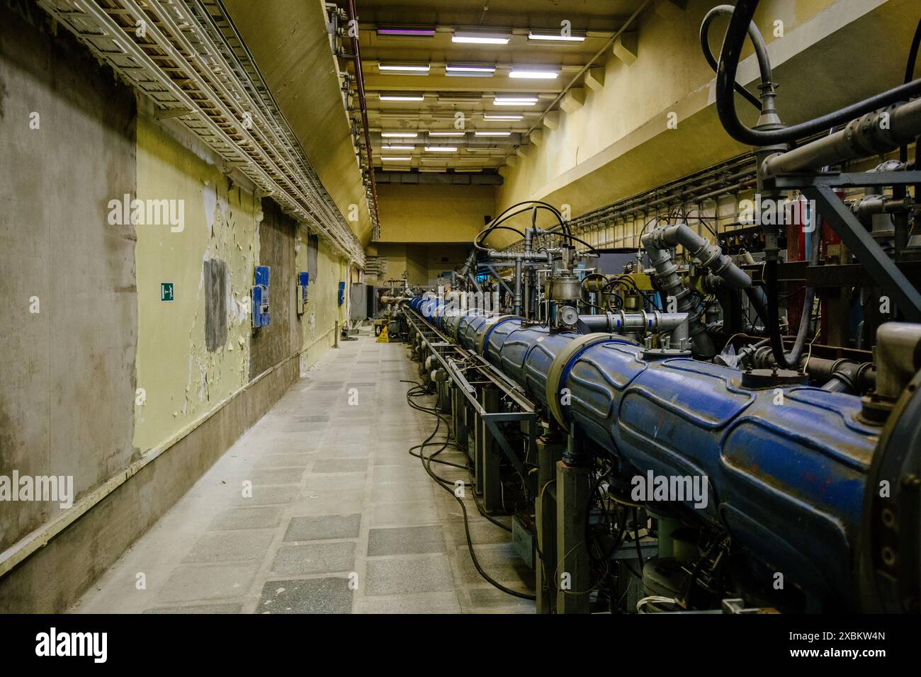 Large metal tube of particle accelerator with connected pipes. Old ...