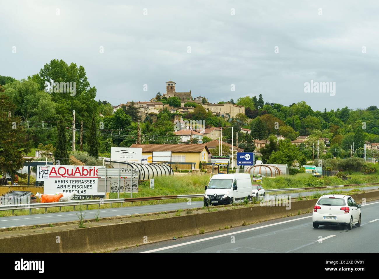 Valence, France - May 7, 2023: A car drives down a road next to a ...