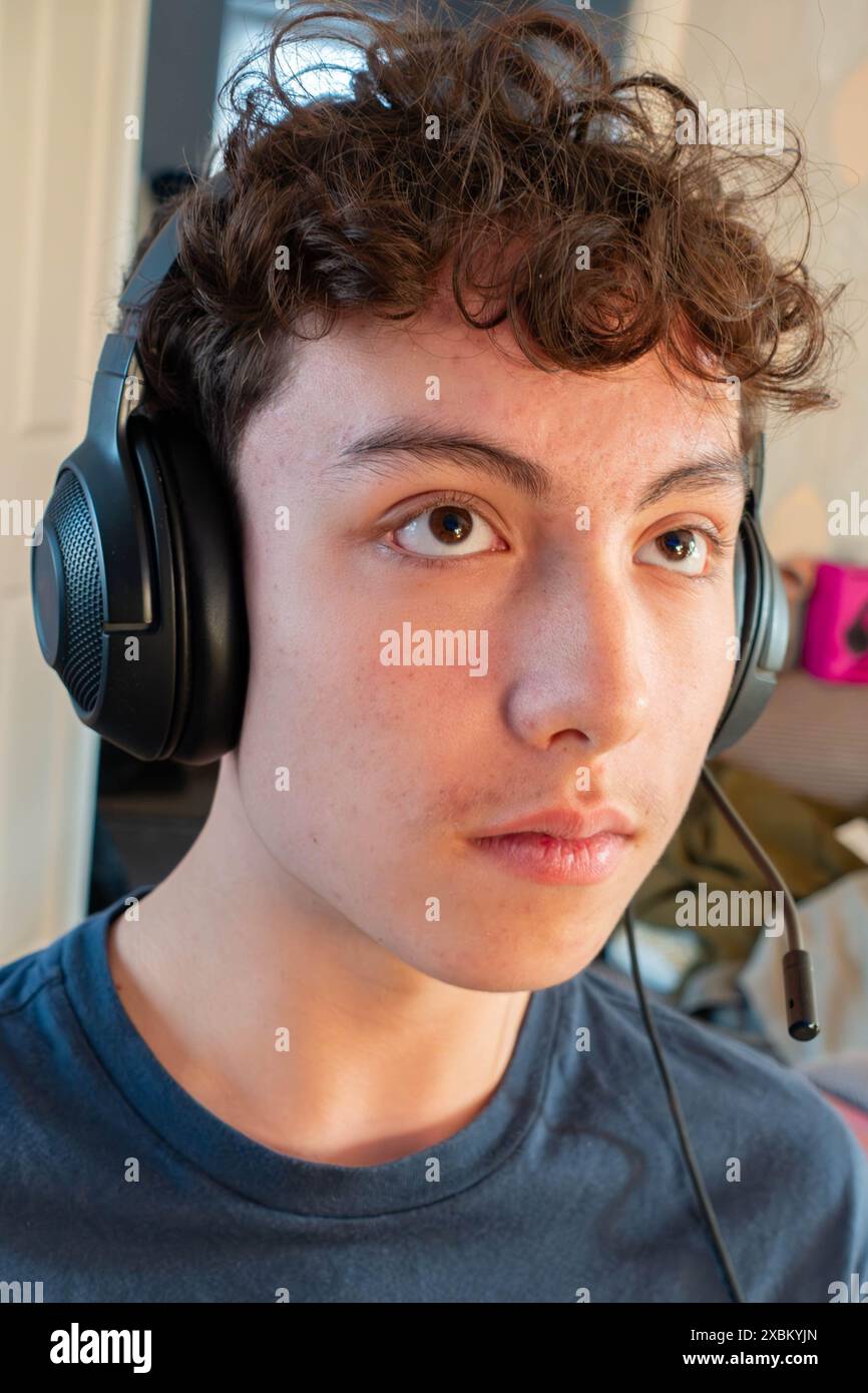 Close up portrait of a teenage boy wearing a gaming headset ...