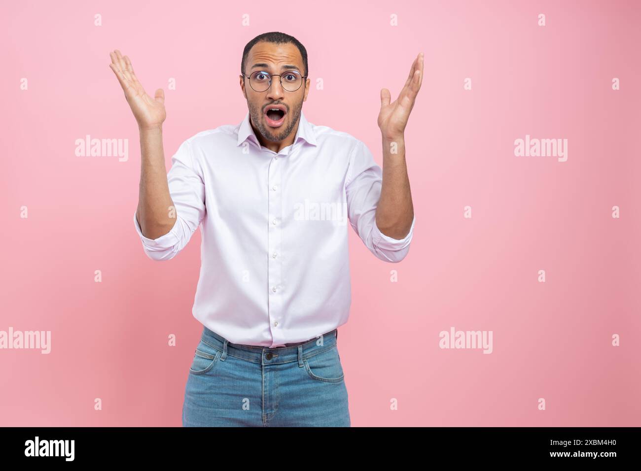 Astonished man in white shirt raised hands saying what Stock Photo - Alamy