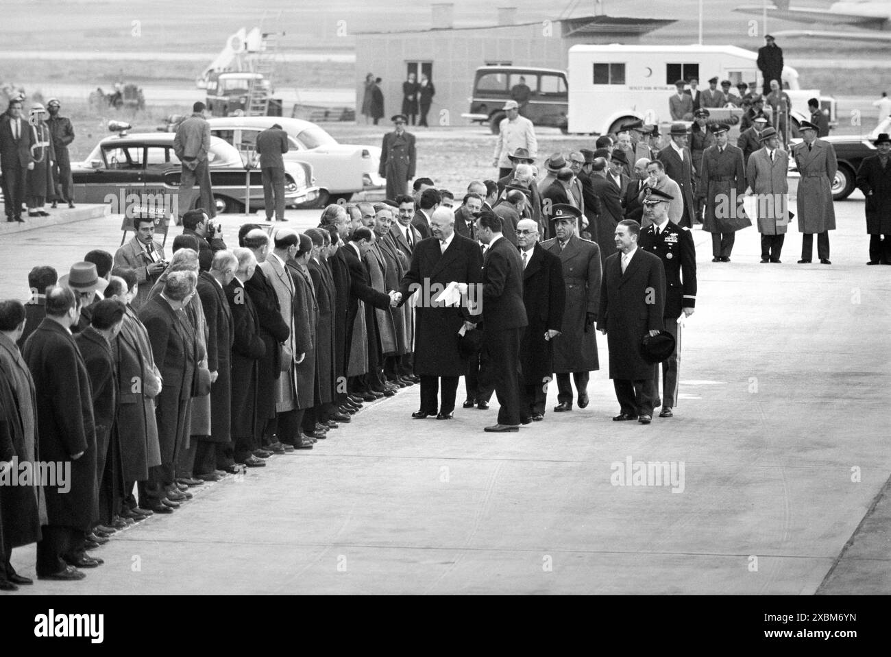 U.S. President Dwight Eisenhower shaking hands with line of men ...