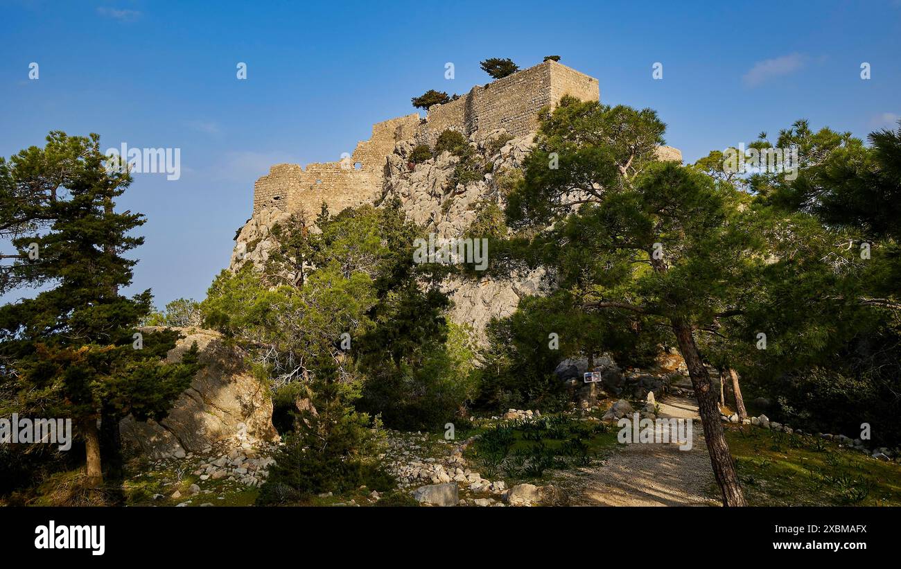 Medieval castle on a hill surrounded by forests and rocks under a clear ...
