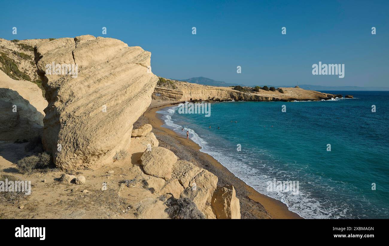 Sunny coastal landscape with rocks, beach and blue sea under a clear ...