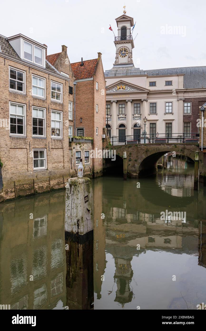 Historic buildings and bridge with clock tower over a quiet canal ...