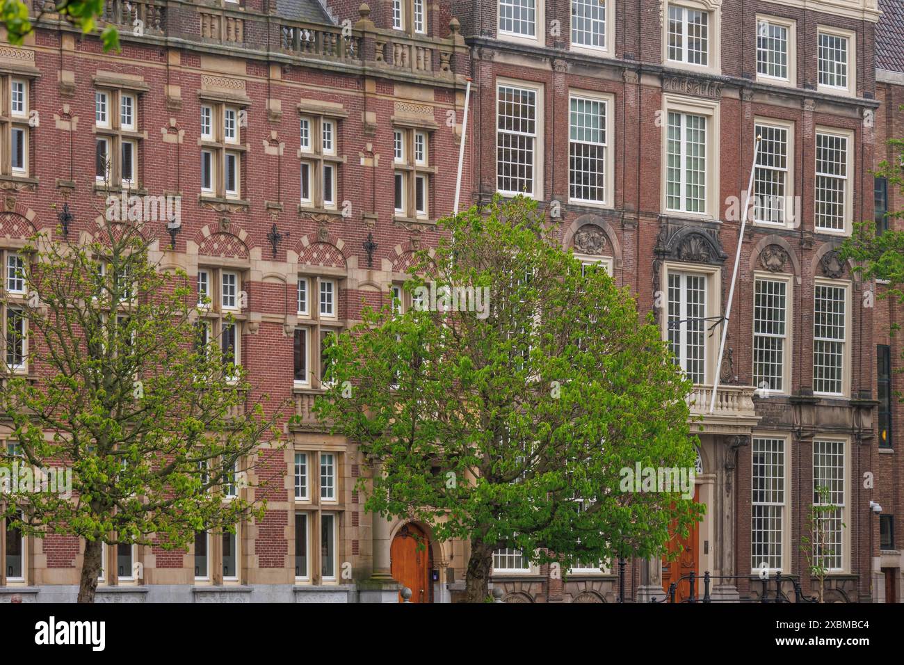 Two historic brick buildings in a quiet street surrounded by green ...