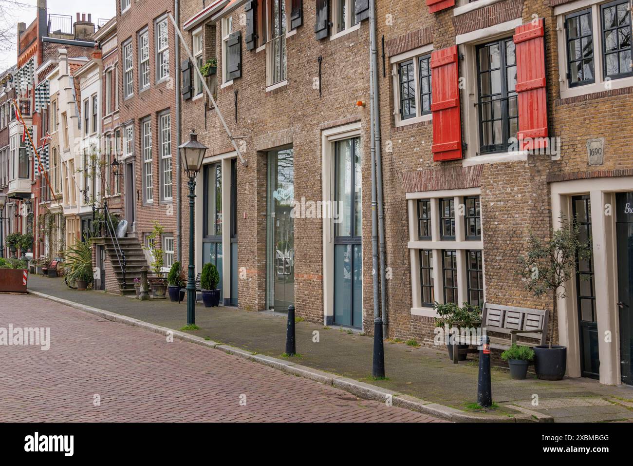 Historic city street lined with brick buildings and red shutters ...