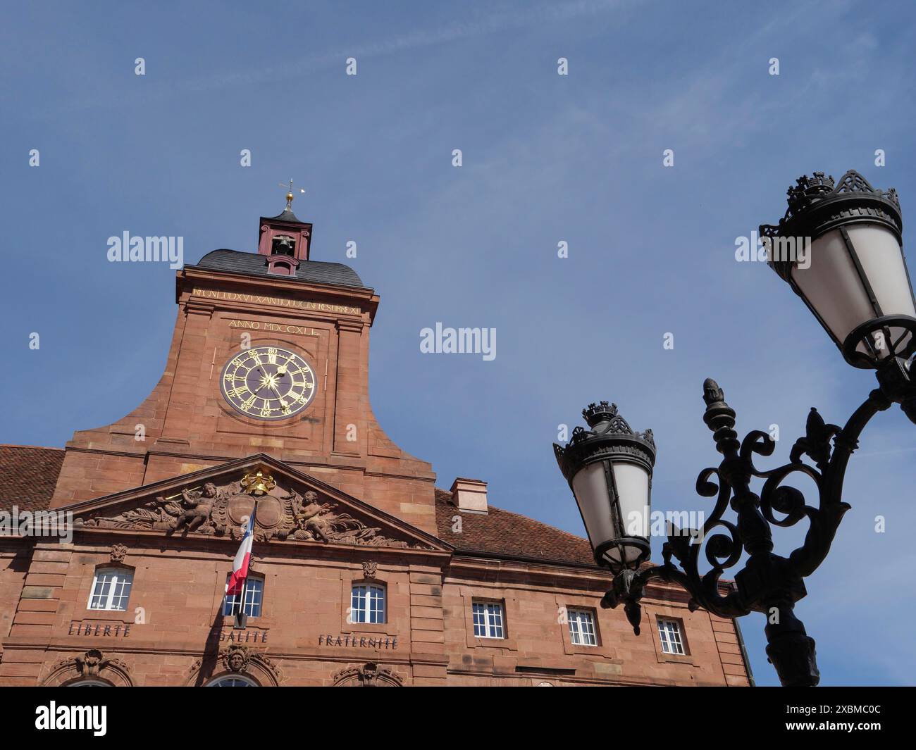 Historic clock tower with decorations and old lanterns under a clear ...