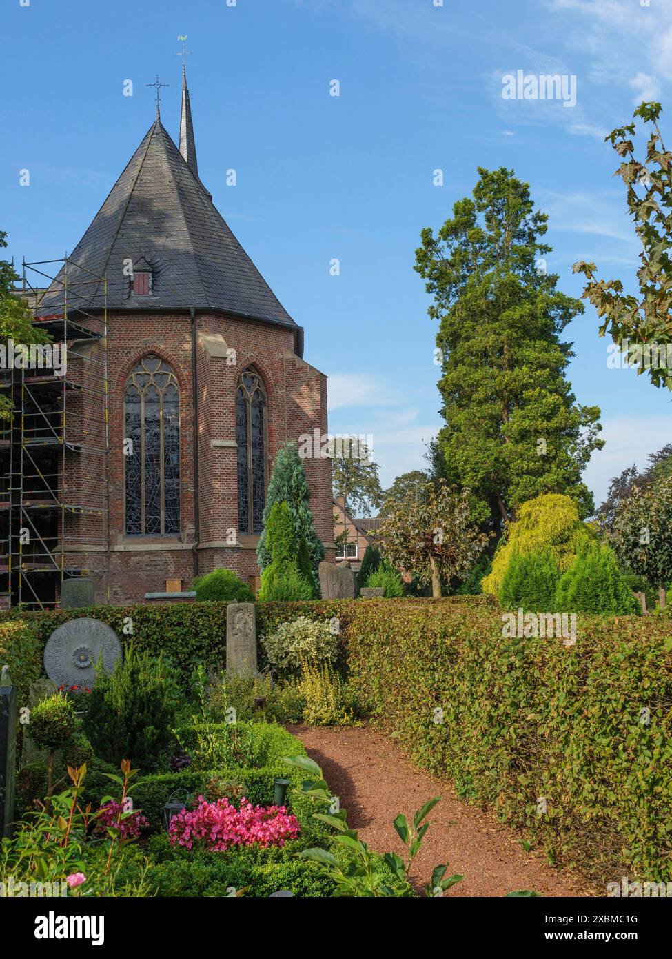 Historic brick church surrounded by manicured hedges and gardens, under ...