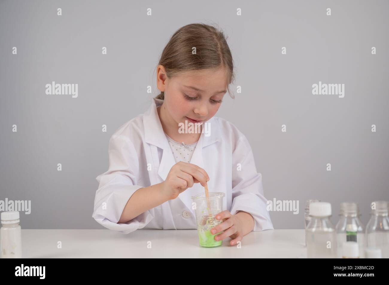 Caucasian girl doing chemical experiments on a white background. Making ...