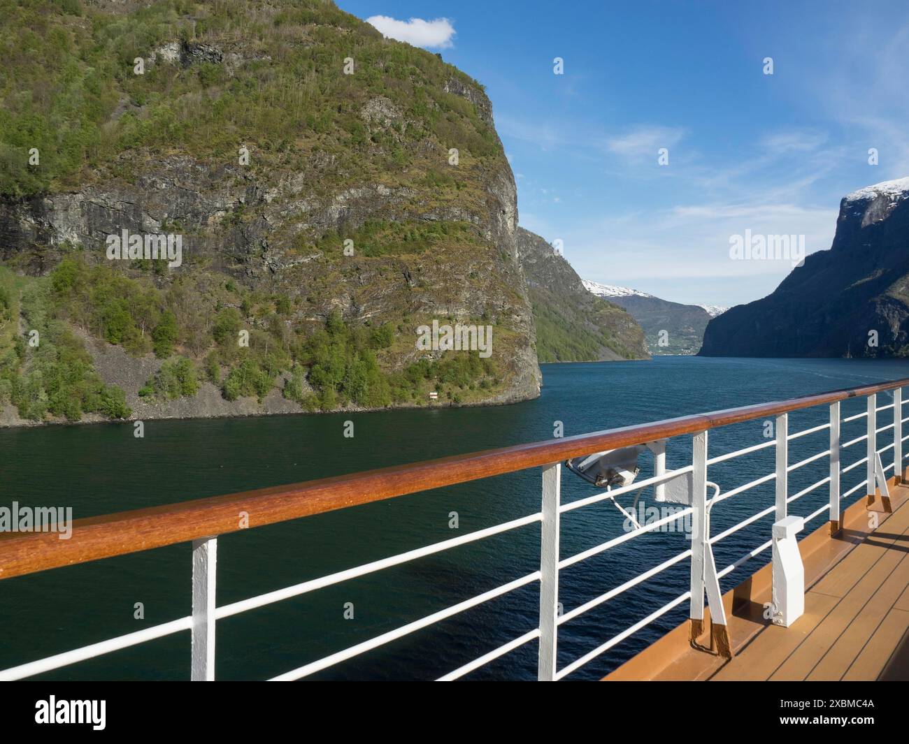View from a ship's railing of a fjord-like landscape with high ...