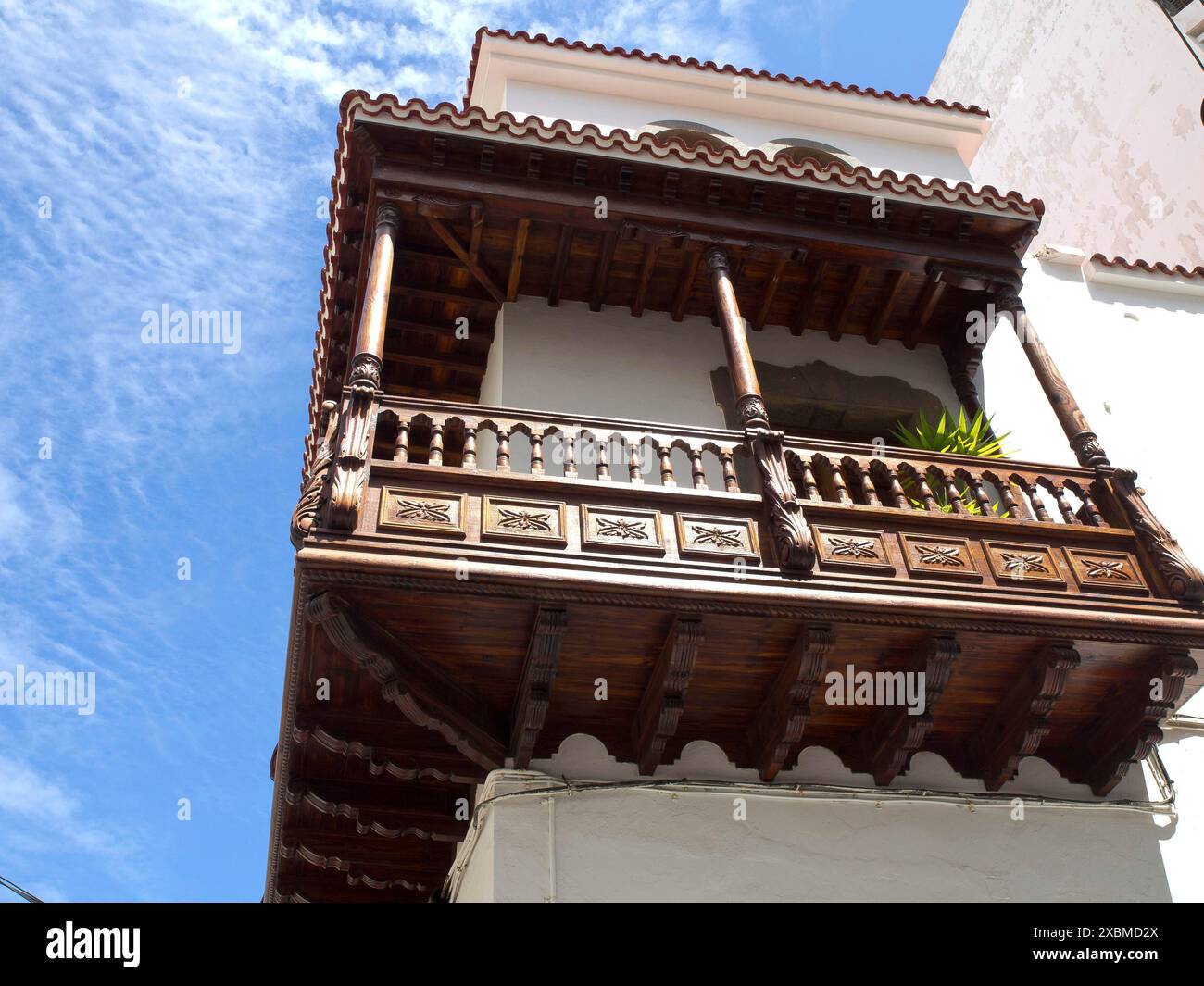 Traditional wooden balcony on a white building with richly decorated ...