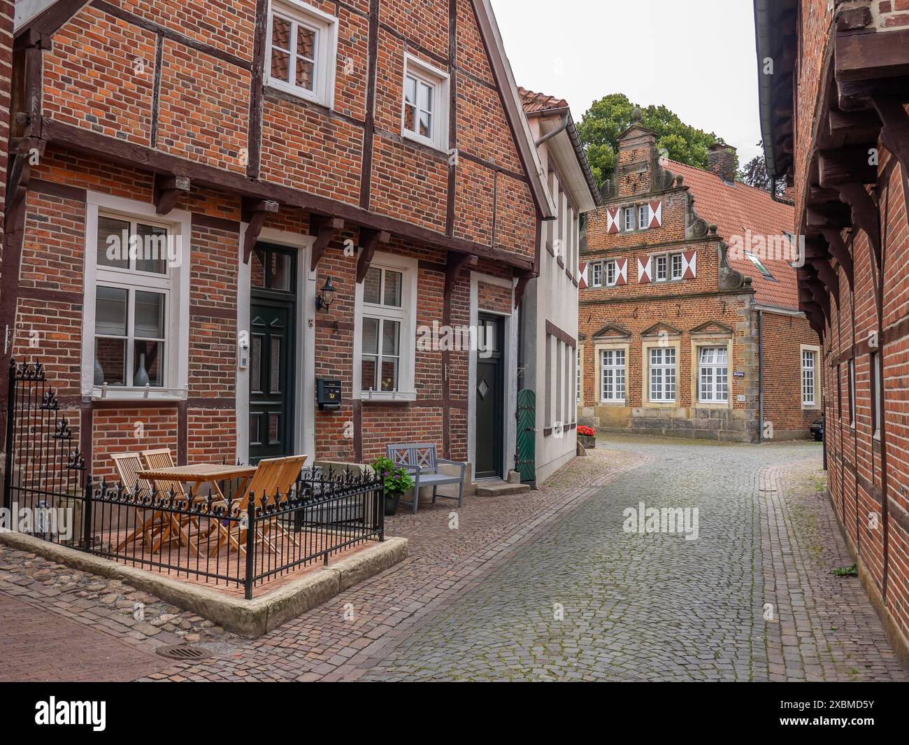 Small cobbled village street lined with old half-timbered and brick ...
