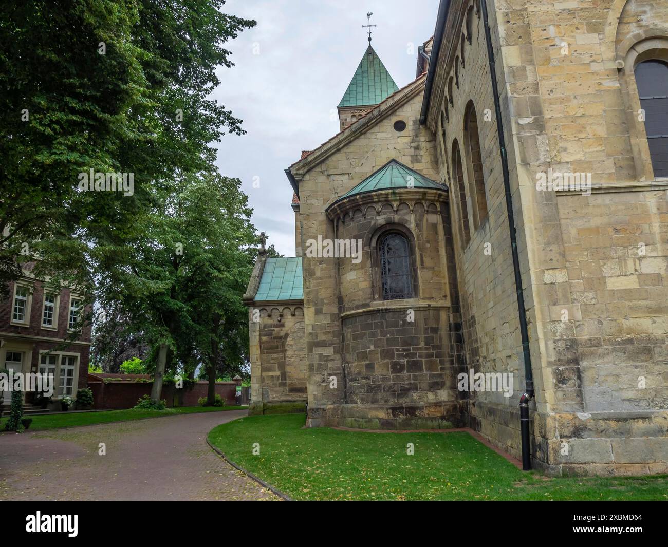 Historic church building with stone wall and arched windows, a path ...