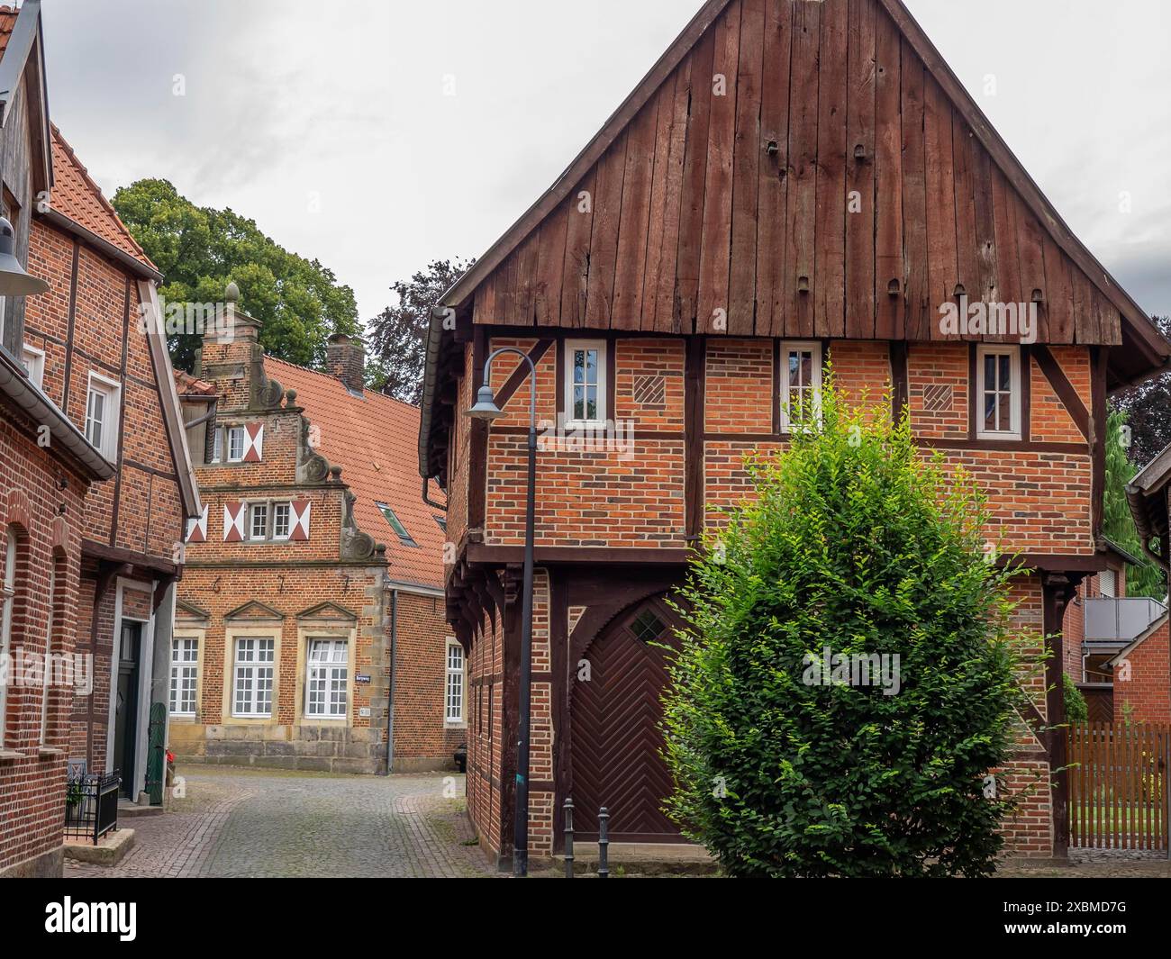 Historic village with half-timbered and brick houses, cobbled street ...