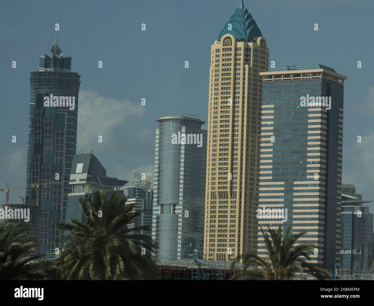 Four tall buildings of modern design with palm trees in the foreground ...