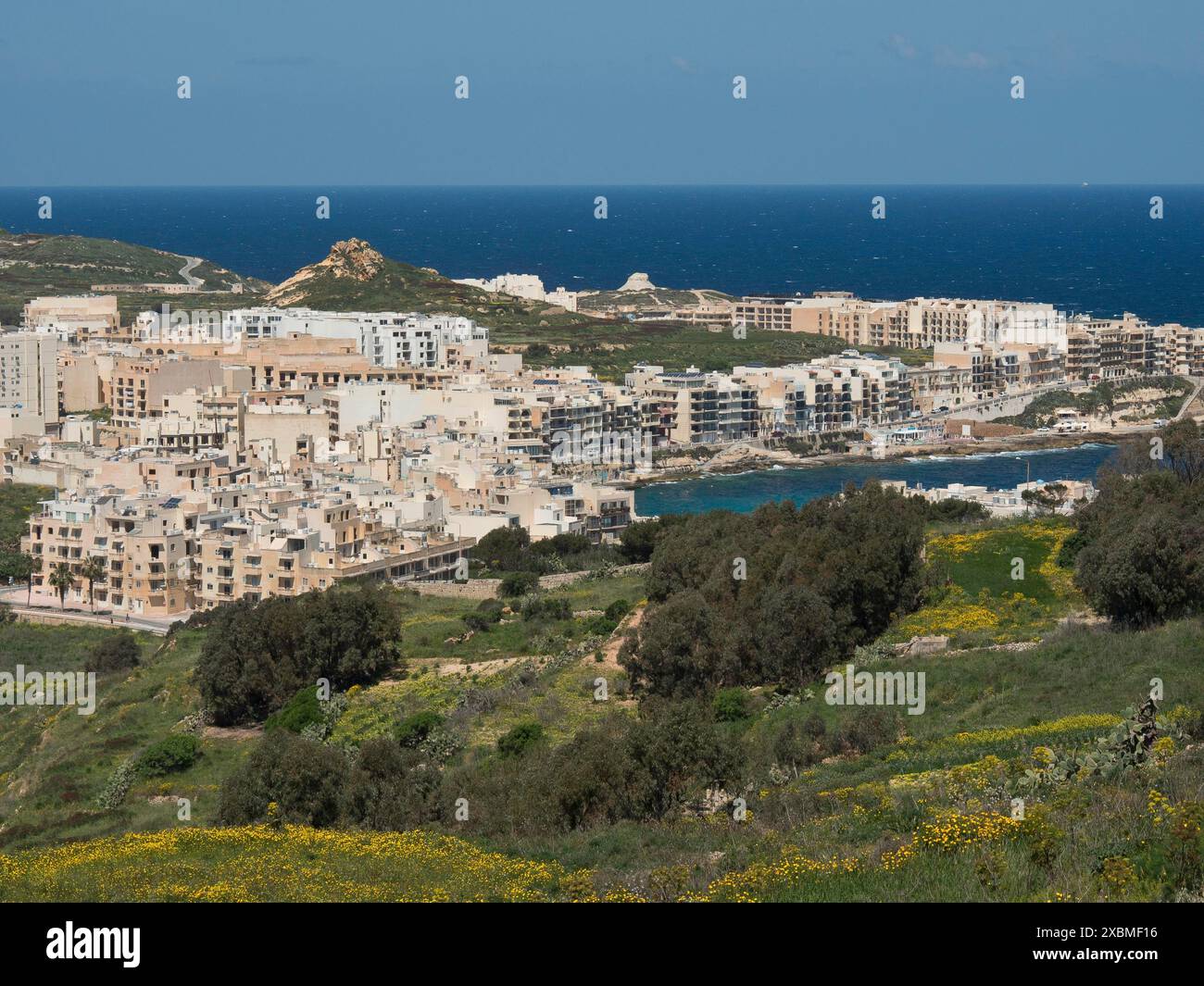 Urban area on the coast with sea, buildings and green surroundings ...