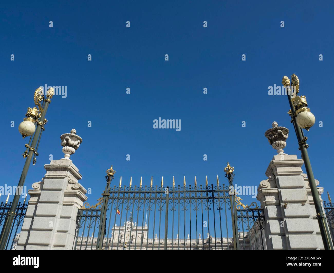 Black, wrought-iron fence with golden decorations encloses a historic ...