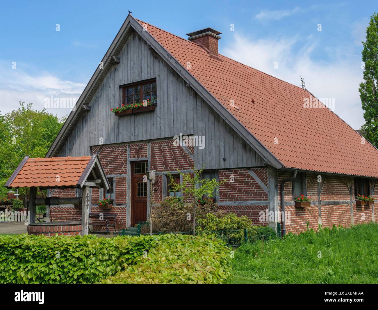 A cosy half-timbered house with a tiled roof, surrounded by a lush ...