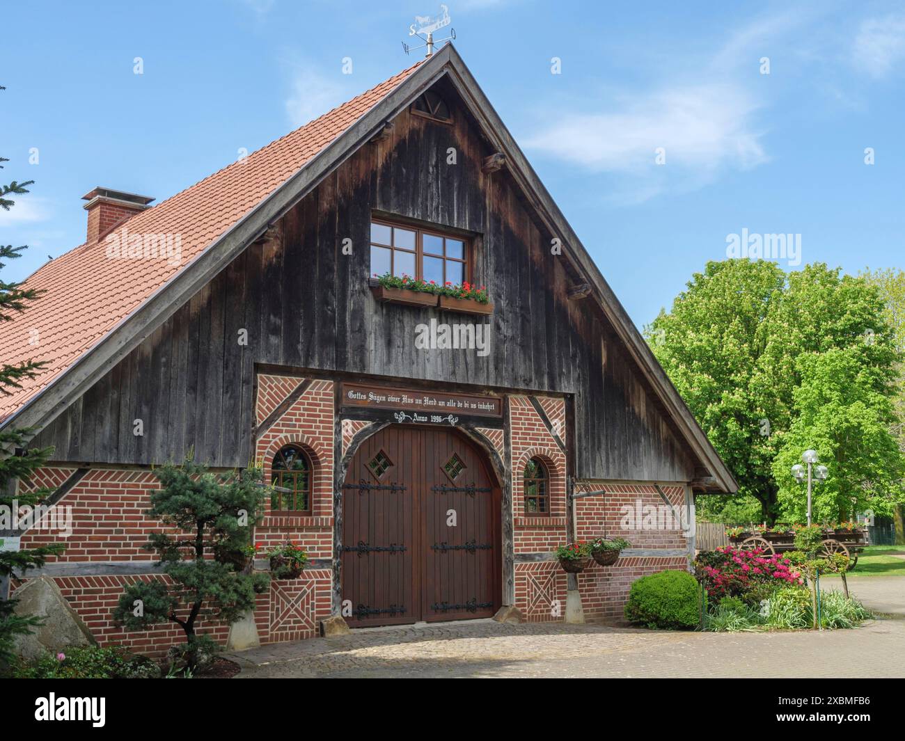 Rustic barn made of wood and brick with flowers and plants in the ...