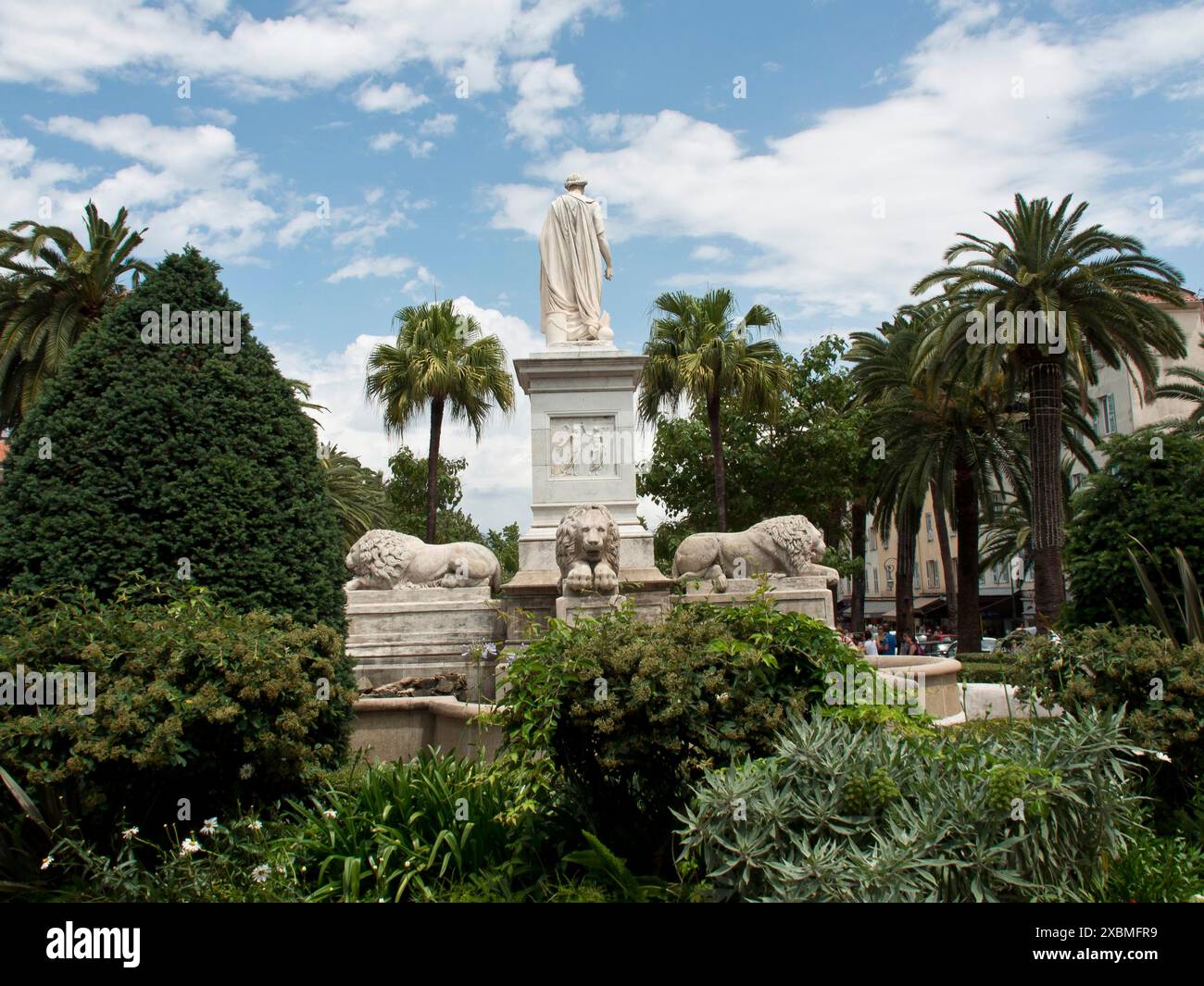 An impressive statue of a lion in a fountain surrounded by palm trees ...