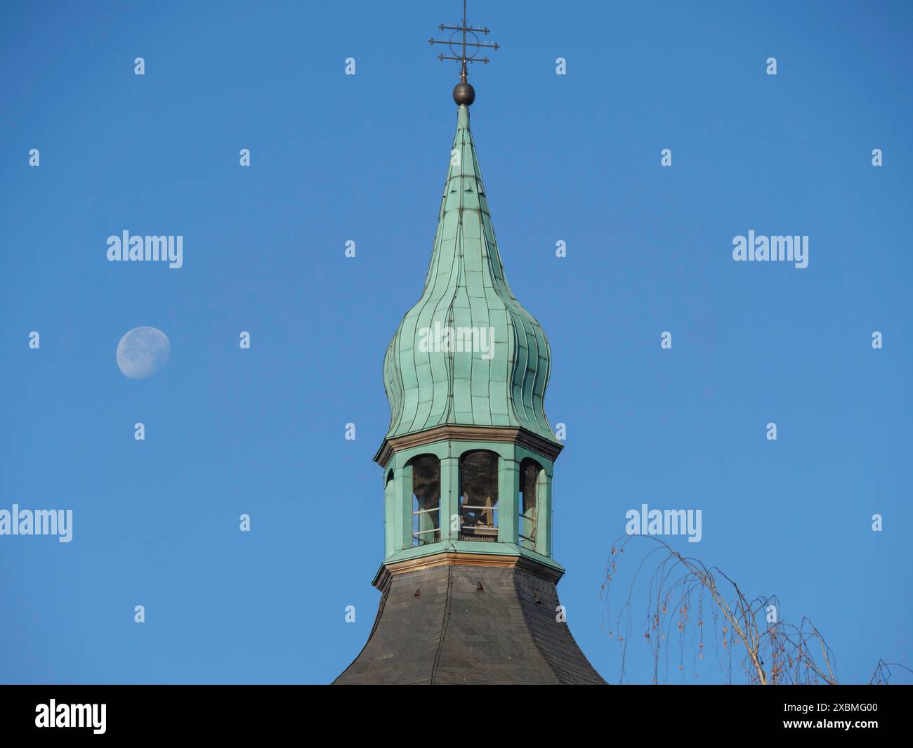 The top of a church tower with a greenish copper roof, next to it the ...