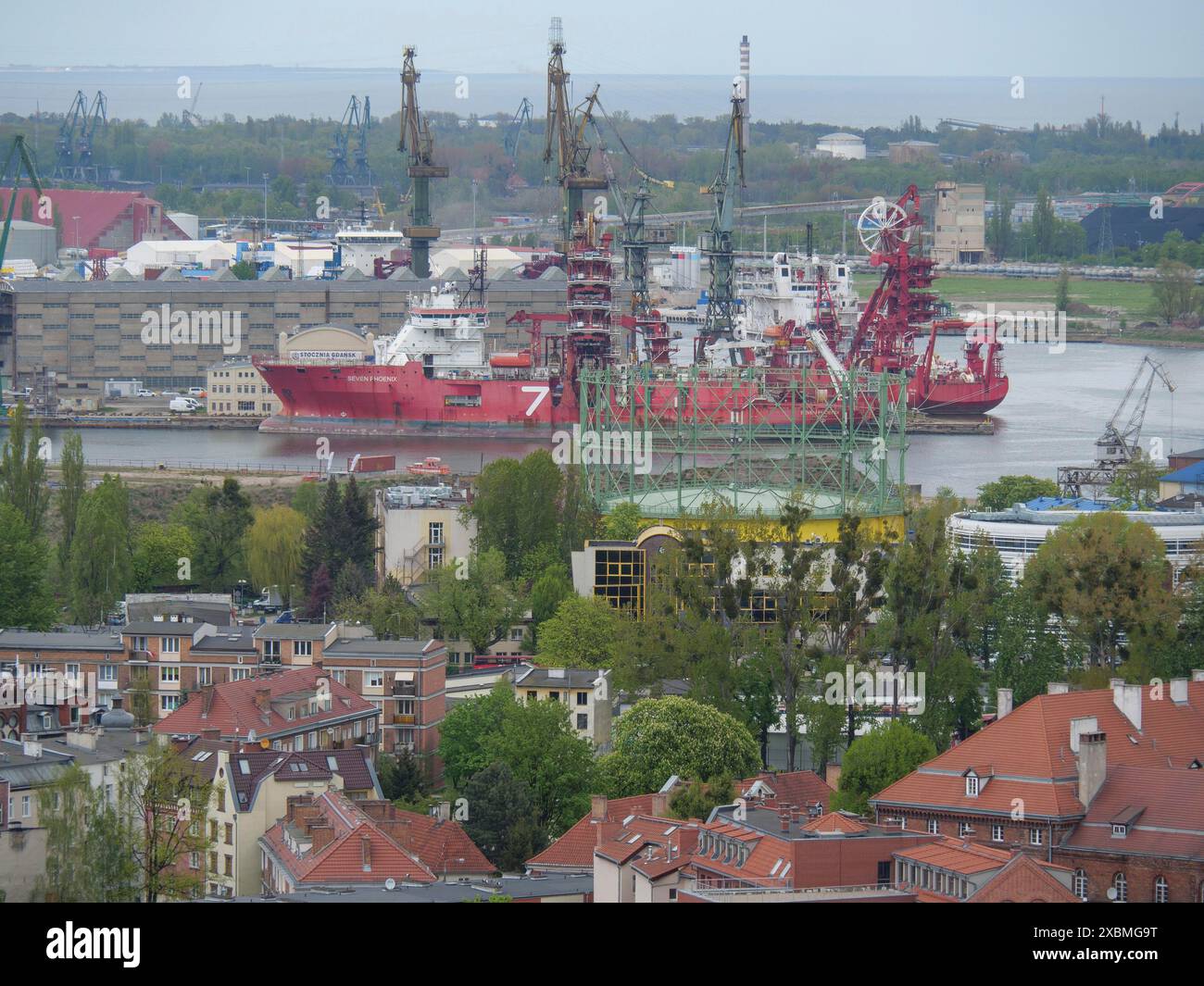 View of a harbour with large ships, cranes and industrial premises on ...