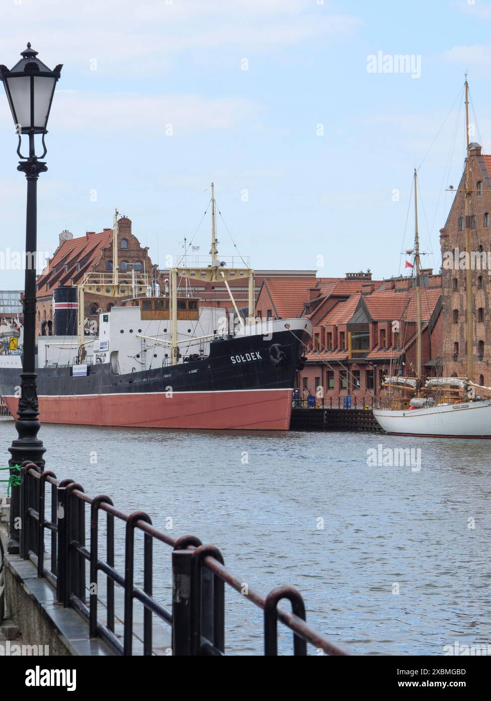 Harbour view with ships and historic brick buildings under a blue sky ...