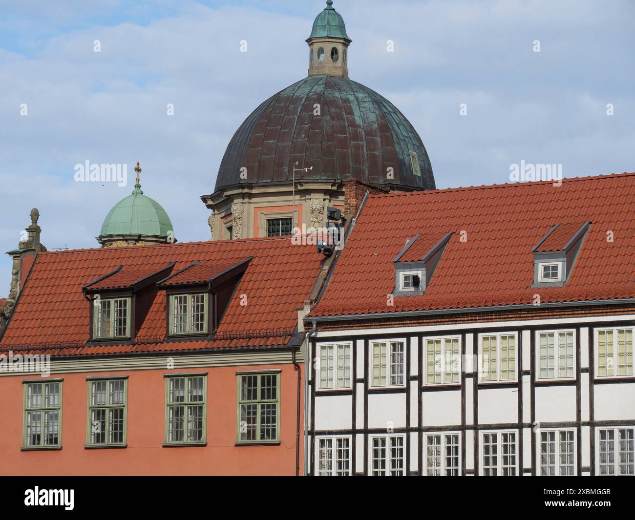 Historic buildings with red tiled roofs and a large dome under a partly ...