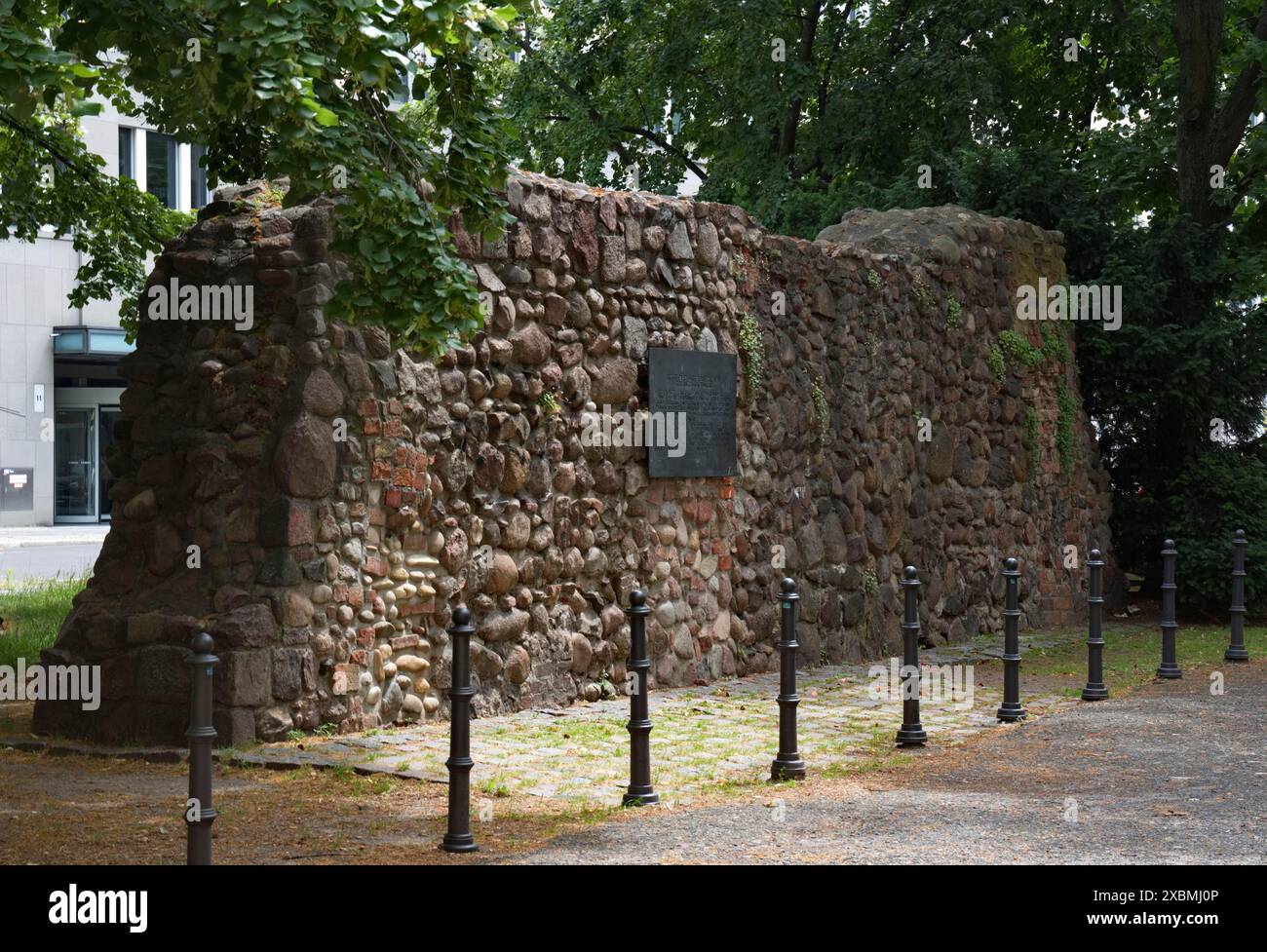 Remains of the medieval city wall, a plaque explains the historical ...