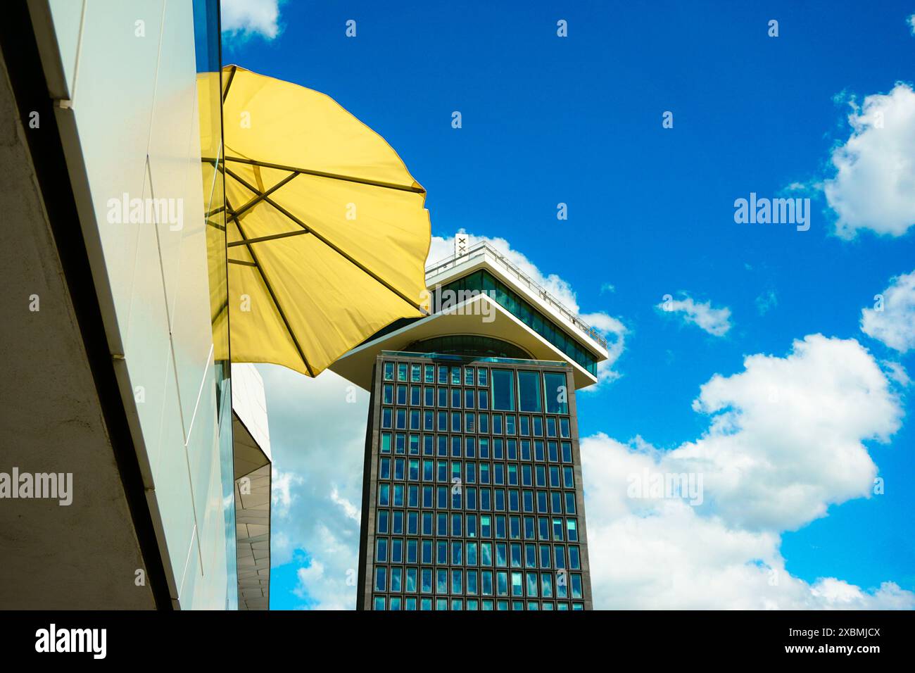a parasol in front of a tall building Stock Photo - Alamy