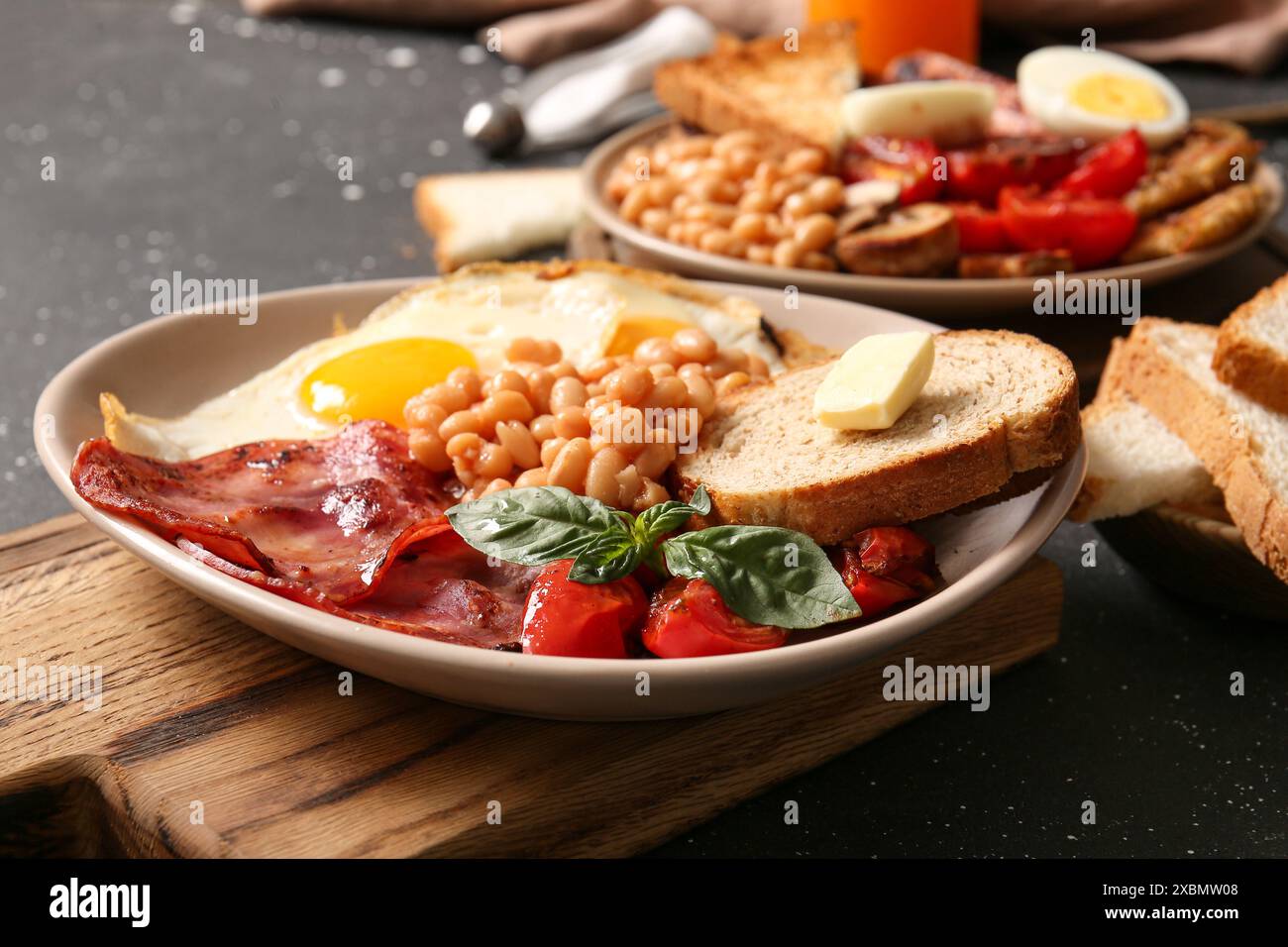 Plates of tasty English breakfast on black background Stock Photo - Alamy