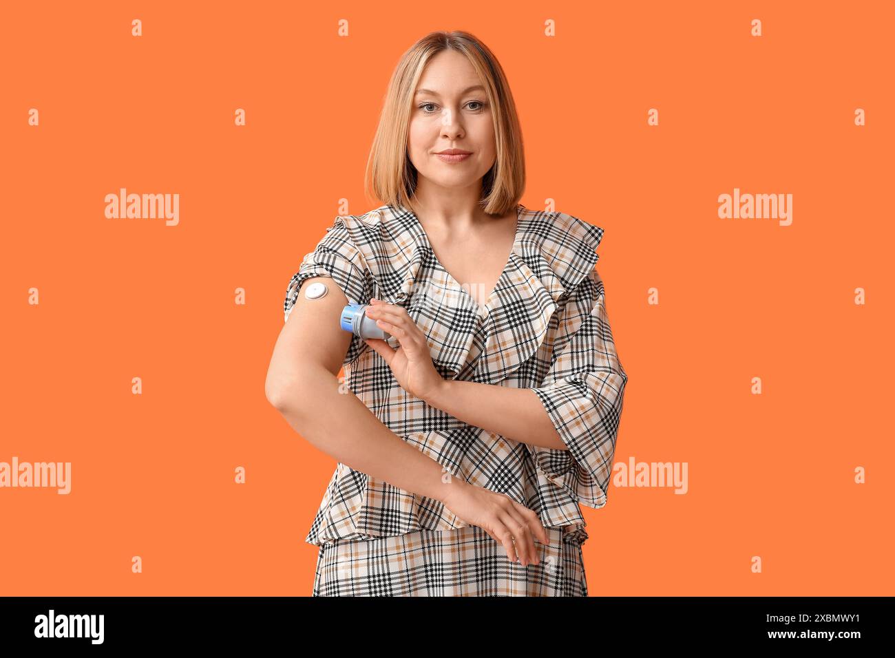Woman with glucose sensor for measuring blood sugar level and ...