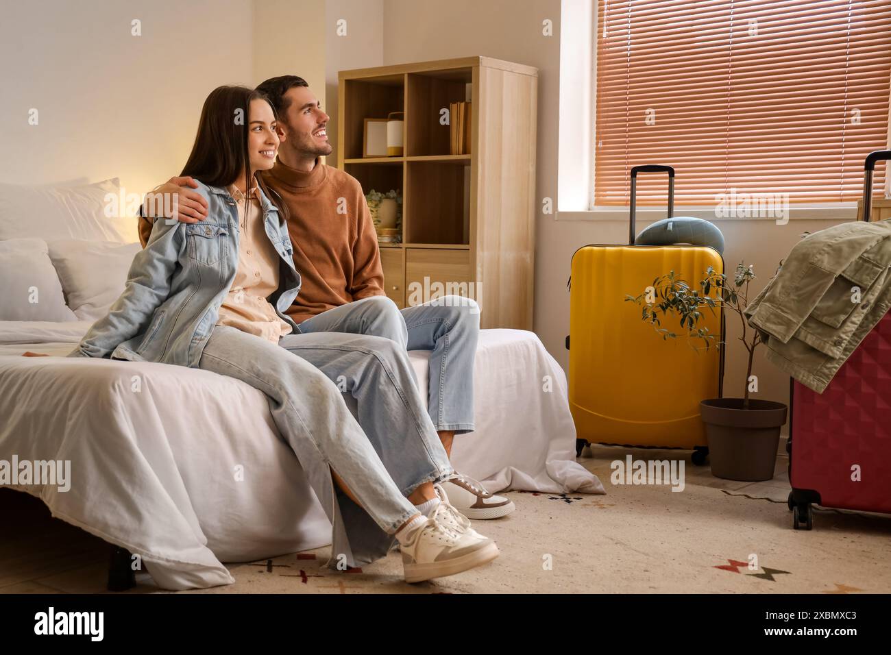 Young couple of tourists checking in hotel room at night Stock Photo ...