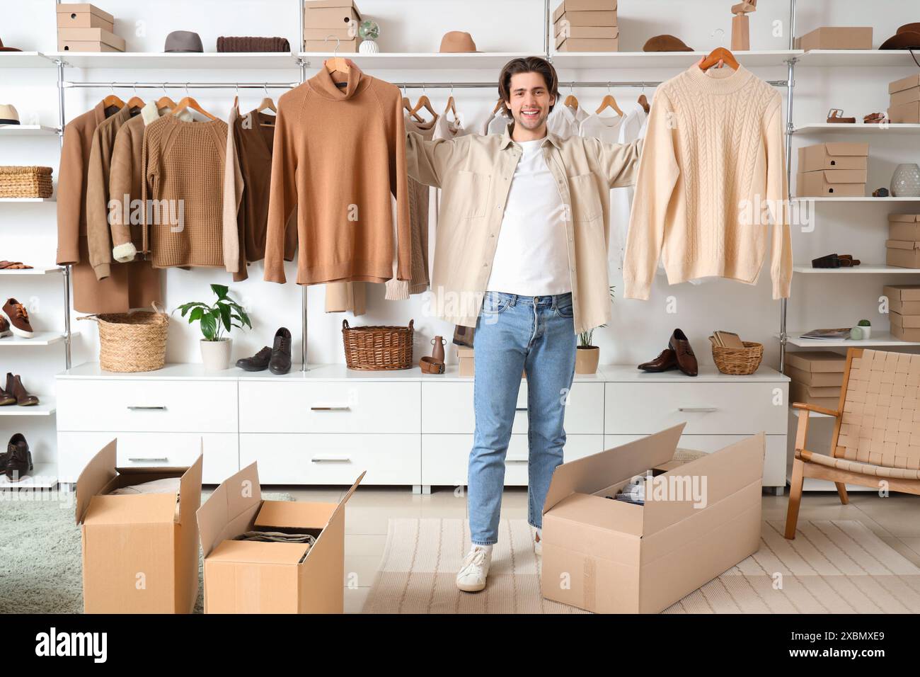 Handsome young man with wardrobe boxes and stylish clothes in dressing ...