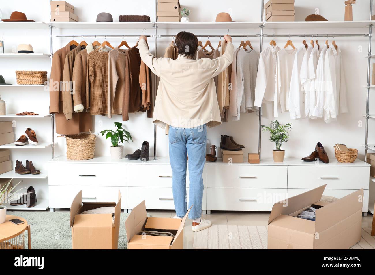 Handsome young man with wardrobe boxes and stylish clothes in dressing ...