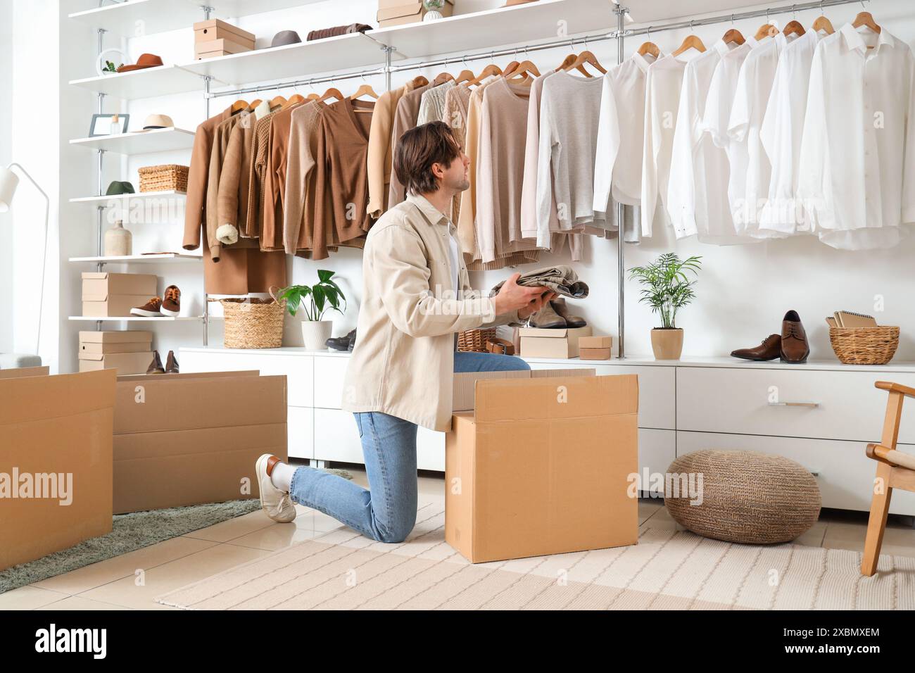 Handsome young man with wardrobe boxes and stylish clothes in dressing ...