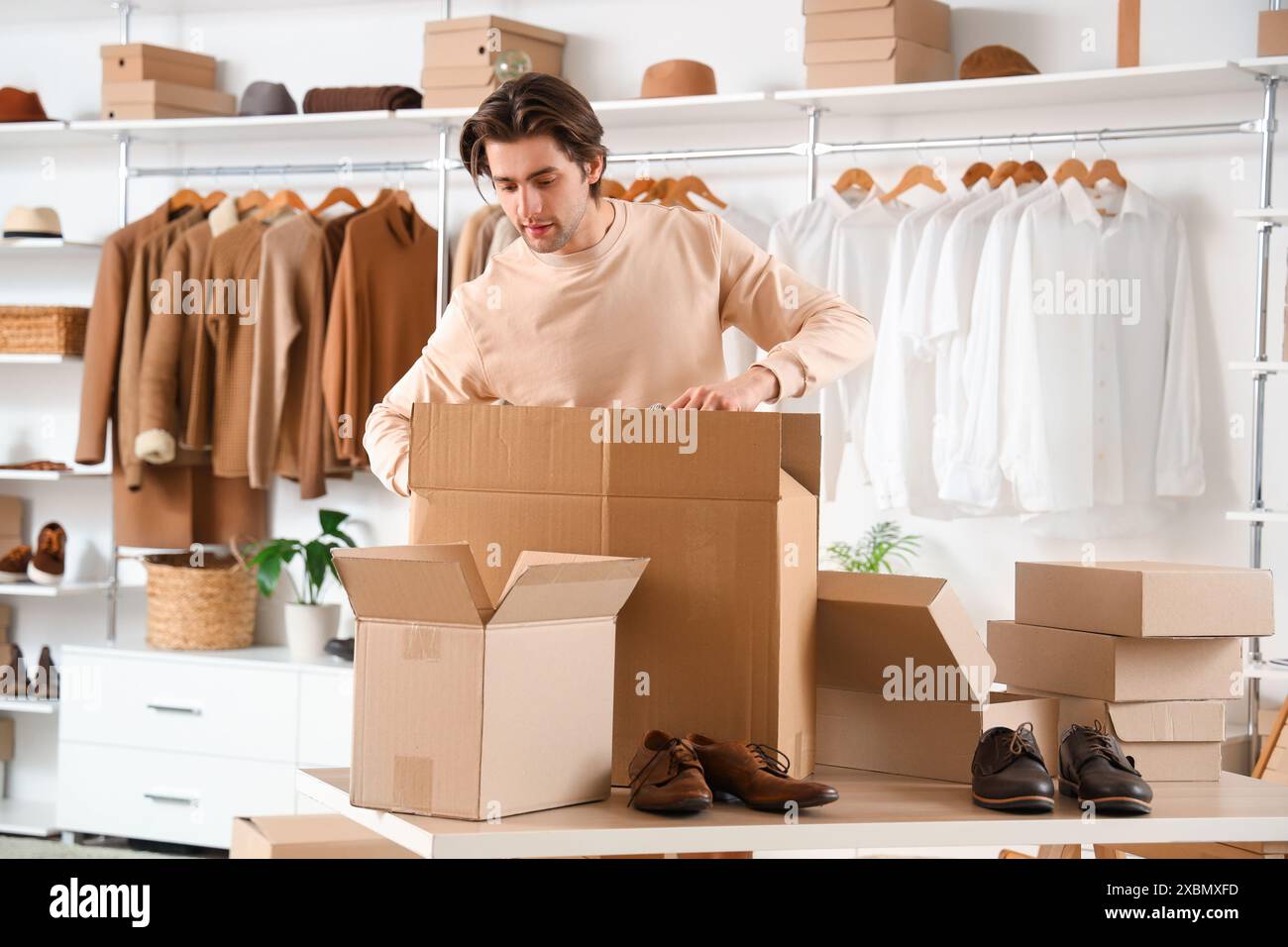 Handsome young man with wardrobe boxes and stylish clothes in dressing ...