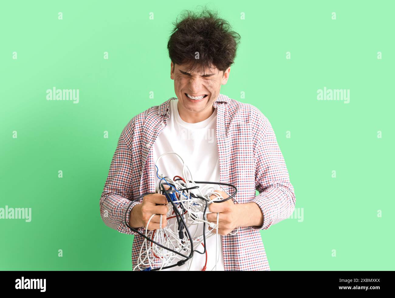 Electrocuted young man with burnt face and wires on green background ...