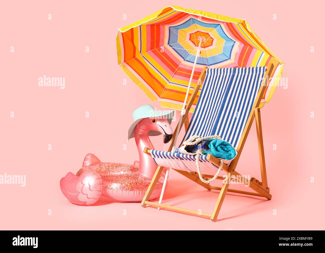 Striped deck chair with colorful umbrella, inflatable ring and beach ...
