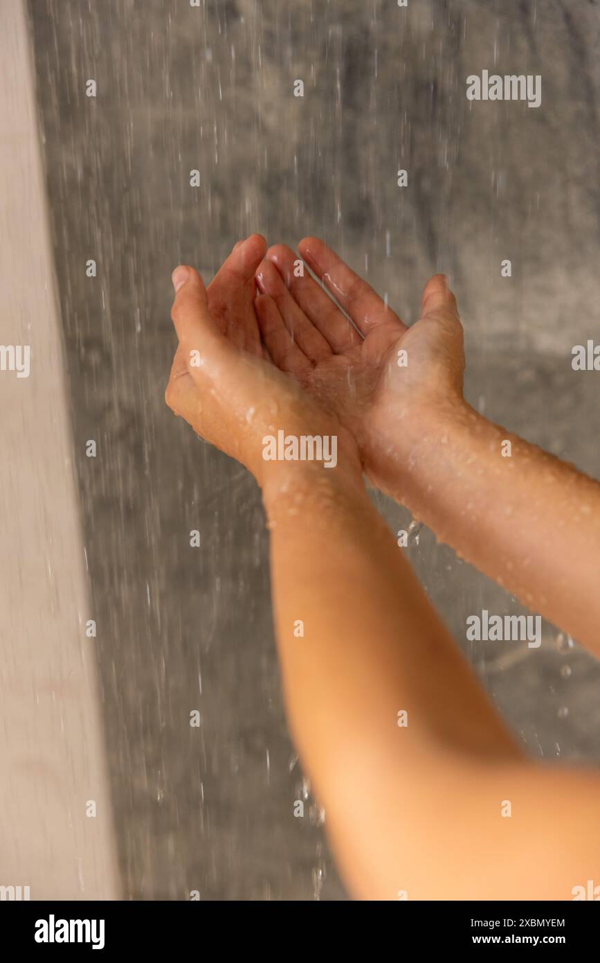Womans hands touching water from shower self care, skincare, wellness ...