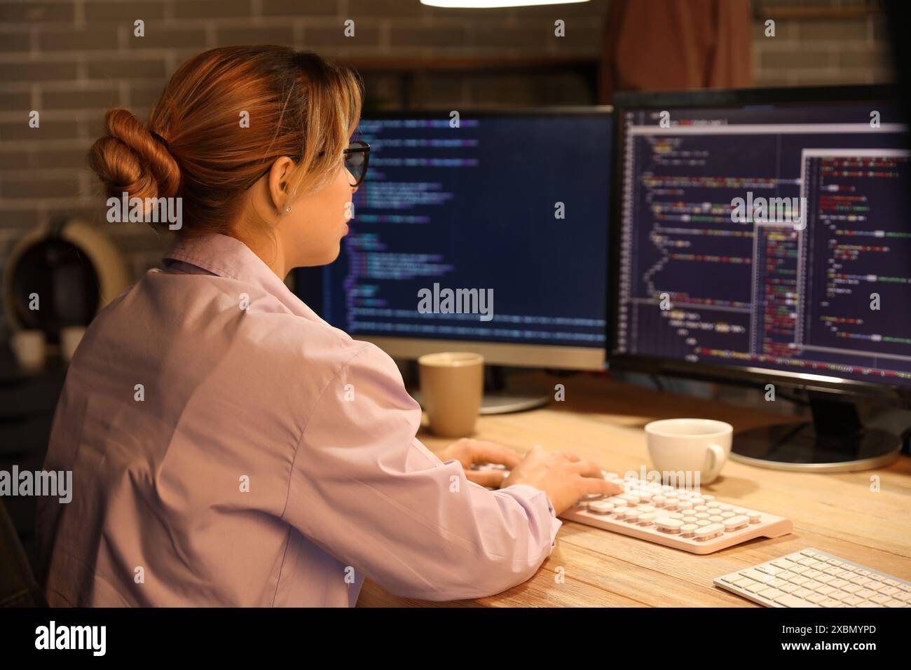 Female programmer working with computer in office at night Stock Photo ...