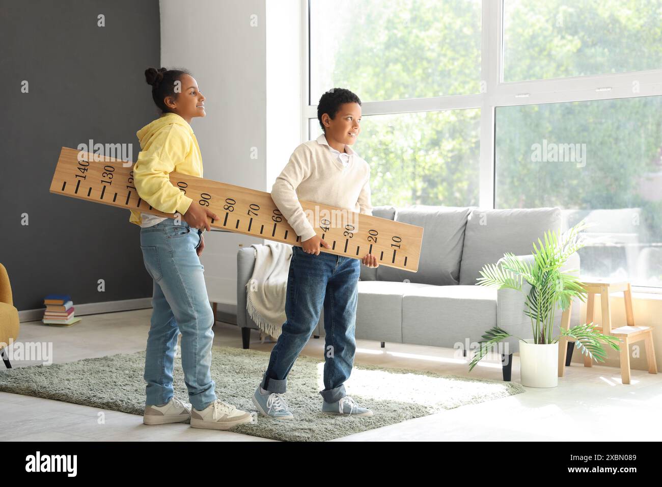 Little African-American children carrying stadiometer at home Stock ...